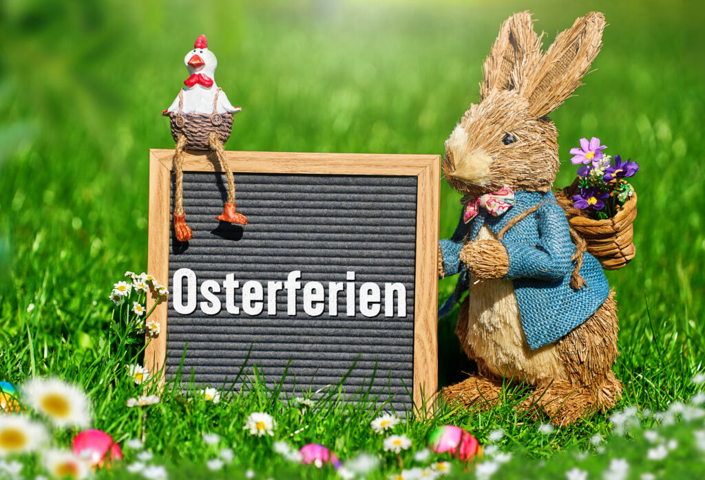 Osterferien Schild mit Osterhase auf Wiese • Ostern Bilder